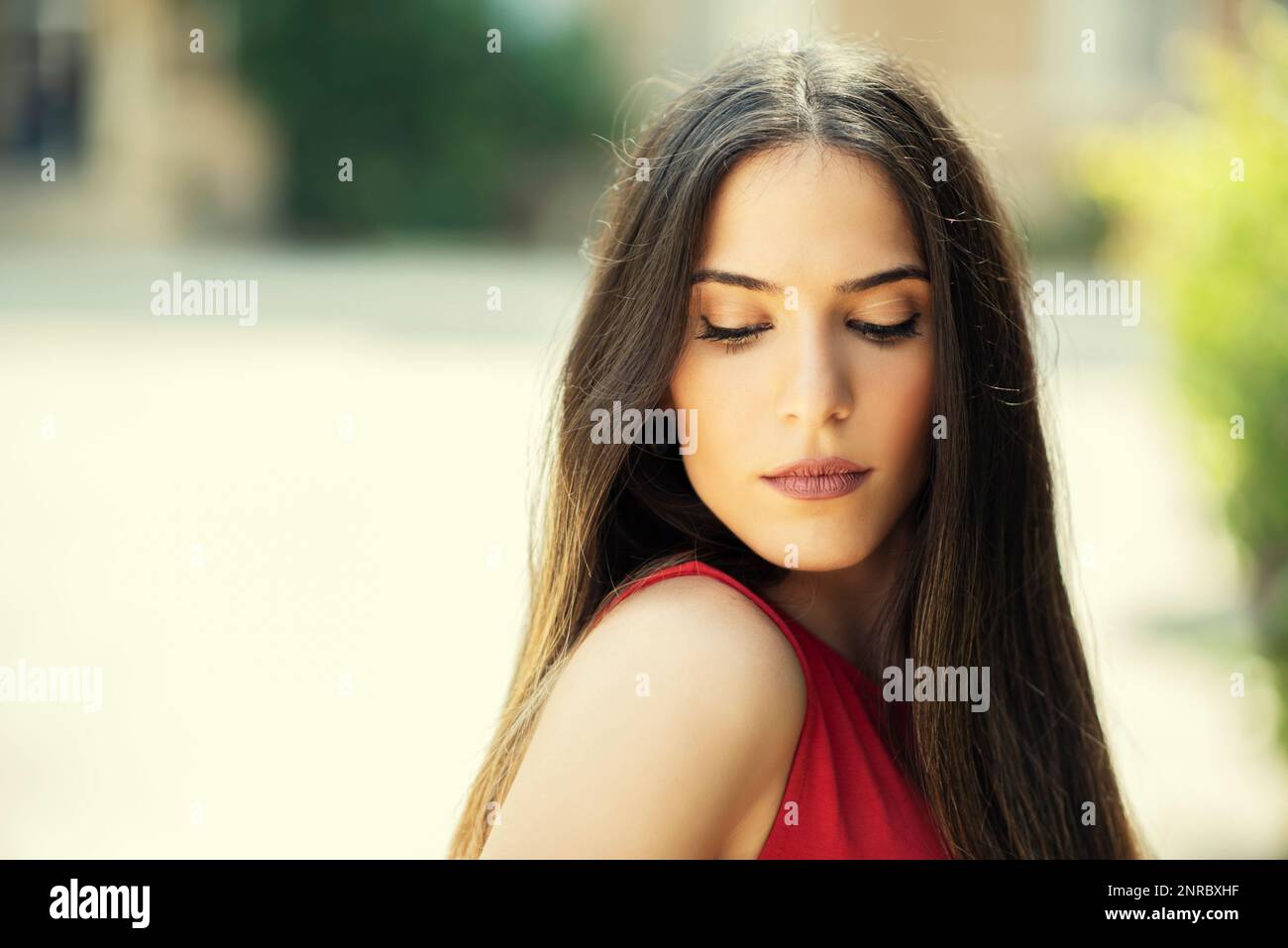 Beautiful young woman looking down outdoors Stock Photo - Alamy