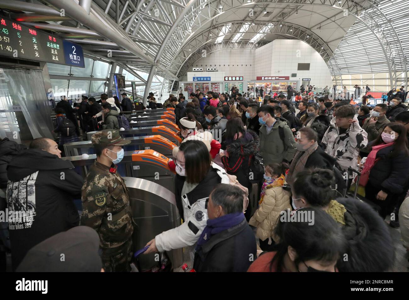 Passengers pass the boarding gates at a railway station in Nantong in ...