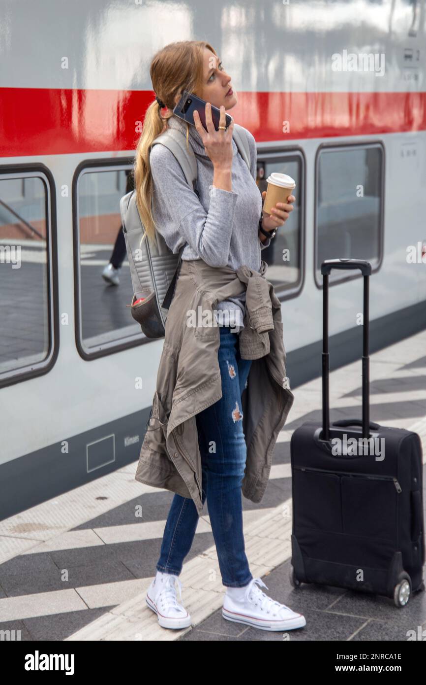 Young woman standing in front of a Deutsche Bahn Intercity train (model ...