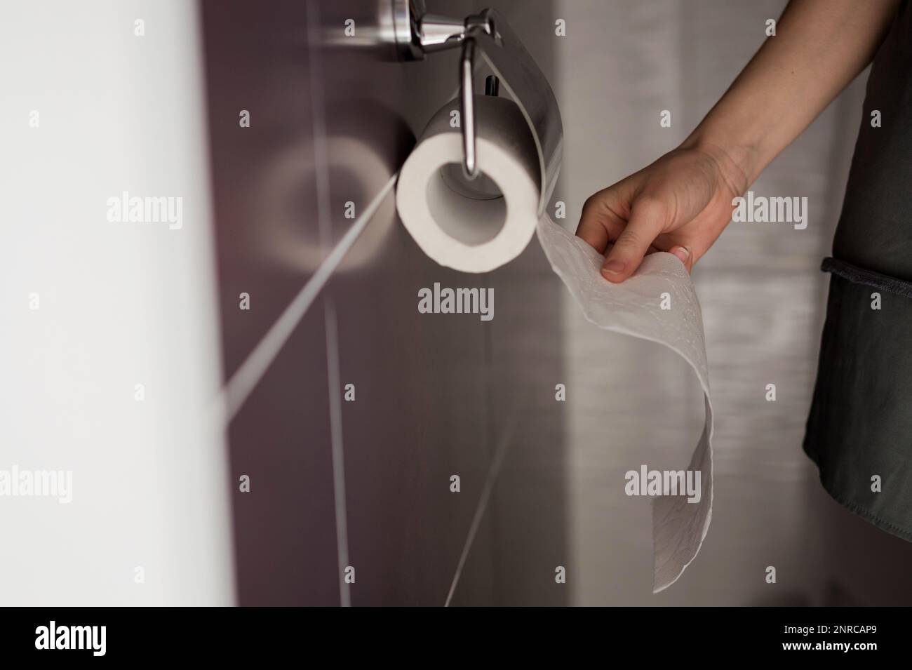 Lady holds a toilet paper roll. Person's Hand Using Toilet Paper Stock ...