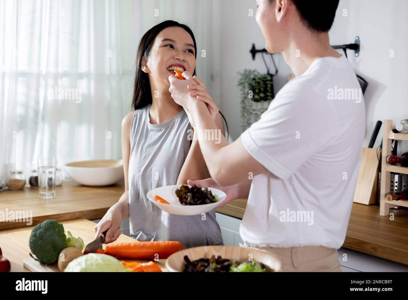 Asian couple in love relationship making a healthy salad together in ...