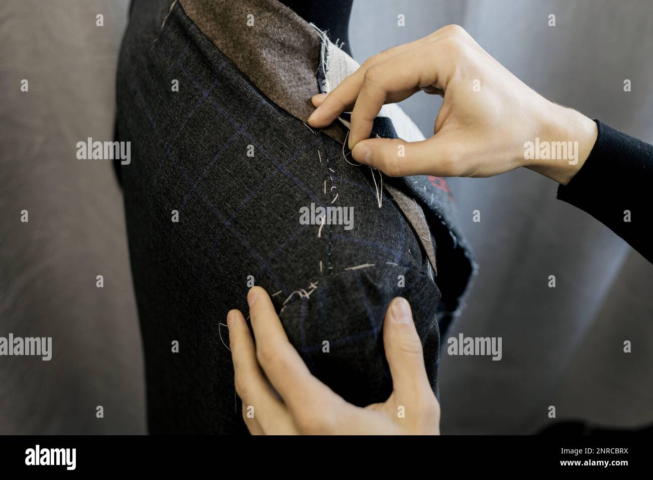 Closeup of tailor fitting bespoke suit to mannequin. tailoring and ...