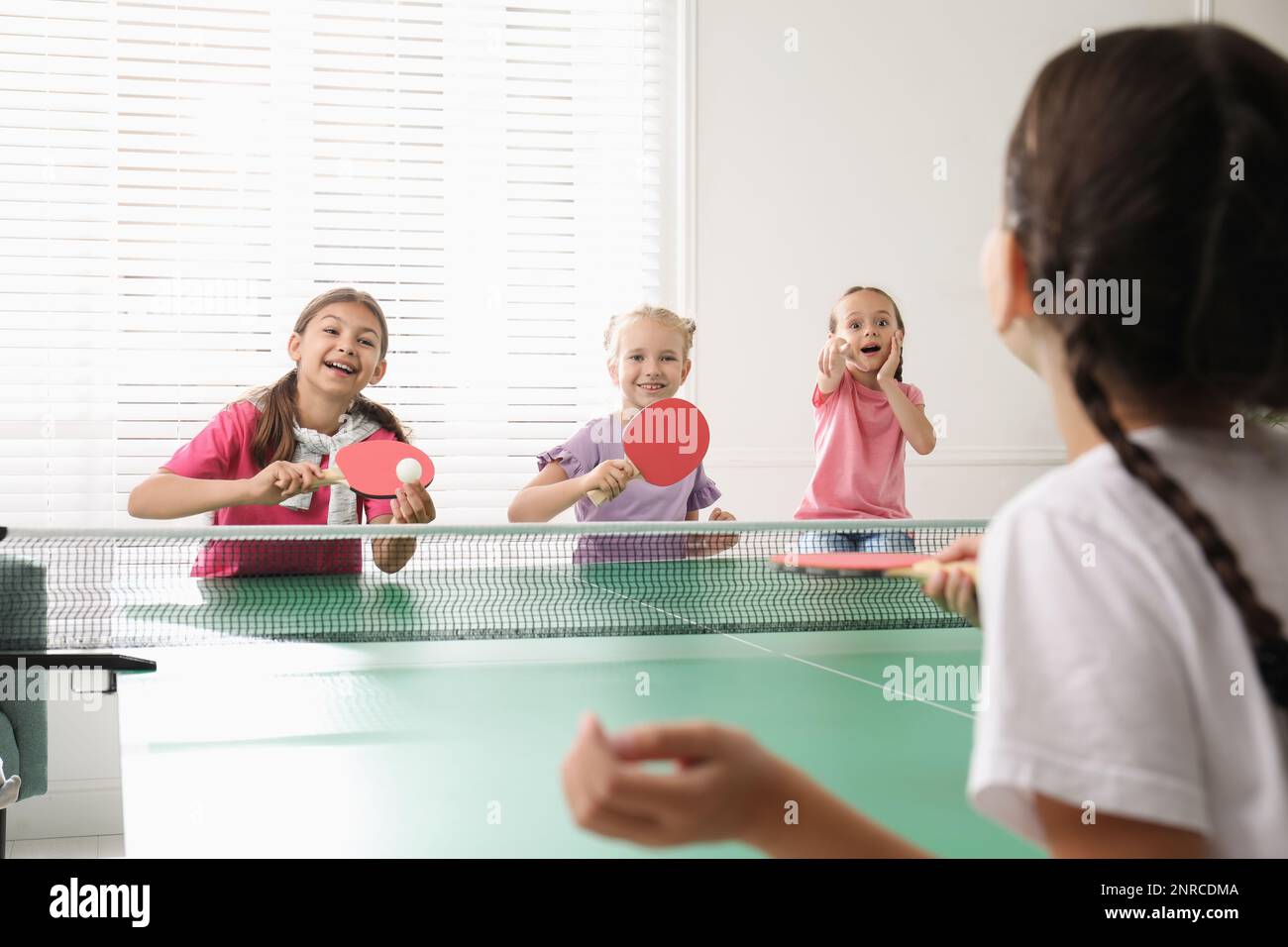 Cute happy children playing ping pong indoors Stock Photo - Alamy