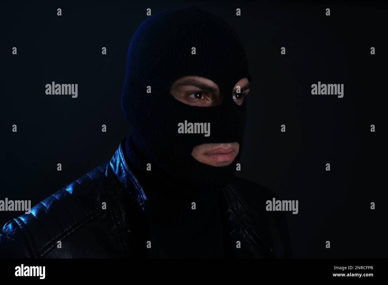 Man wearing knitted balaclava on black background Stock Photo - Alamy