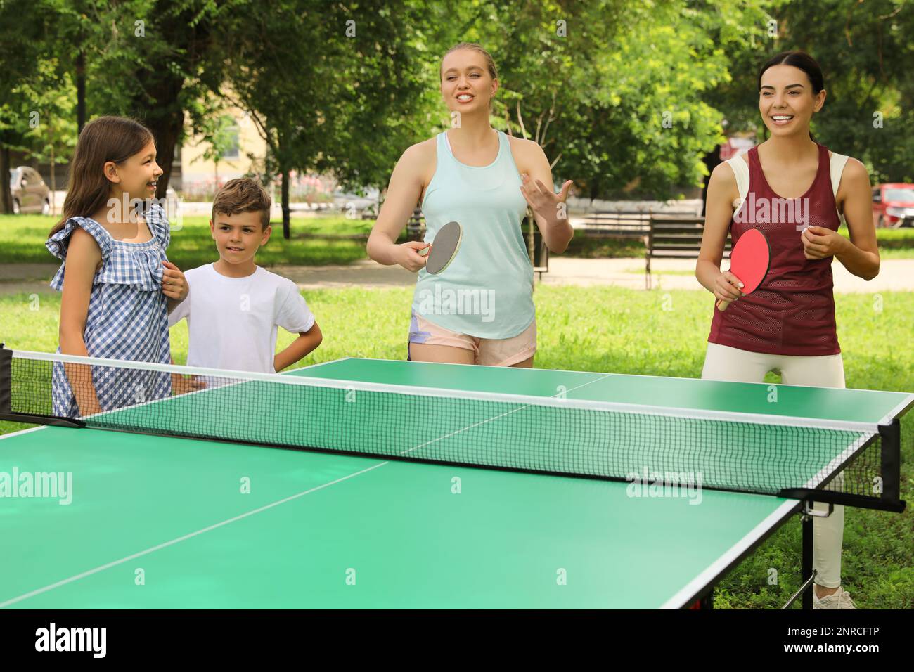Happy family with children playing ping pong in park Stock Photo - Alamy