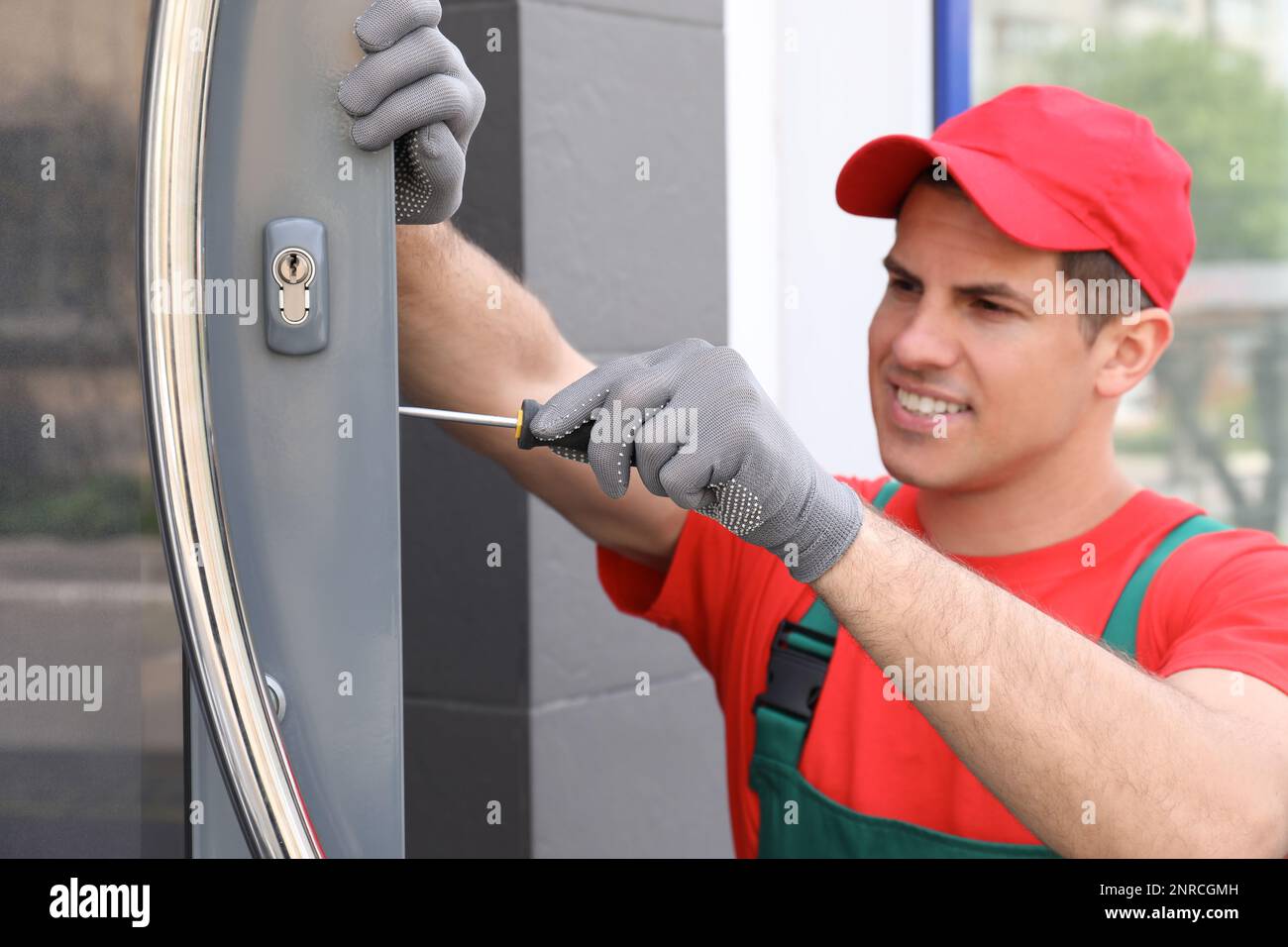 Happy handyman fixing door hi-res stock photography and images - Alamy