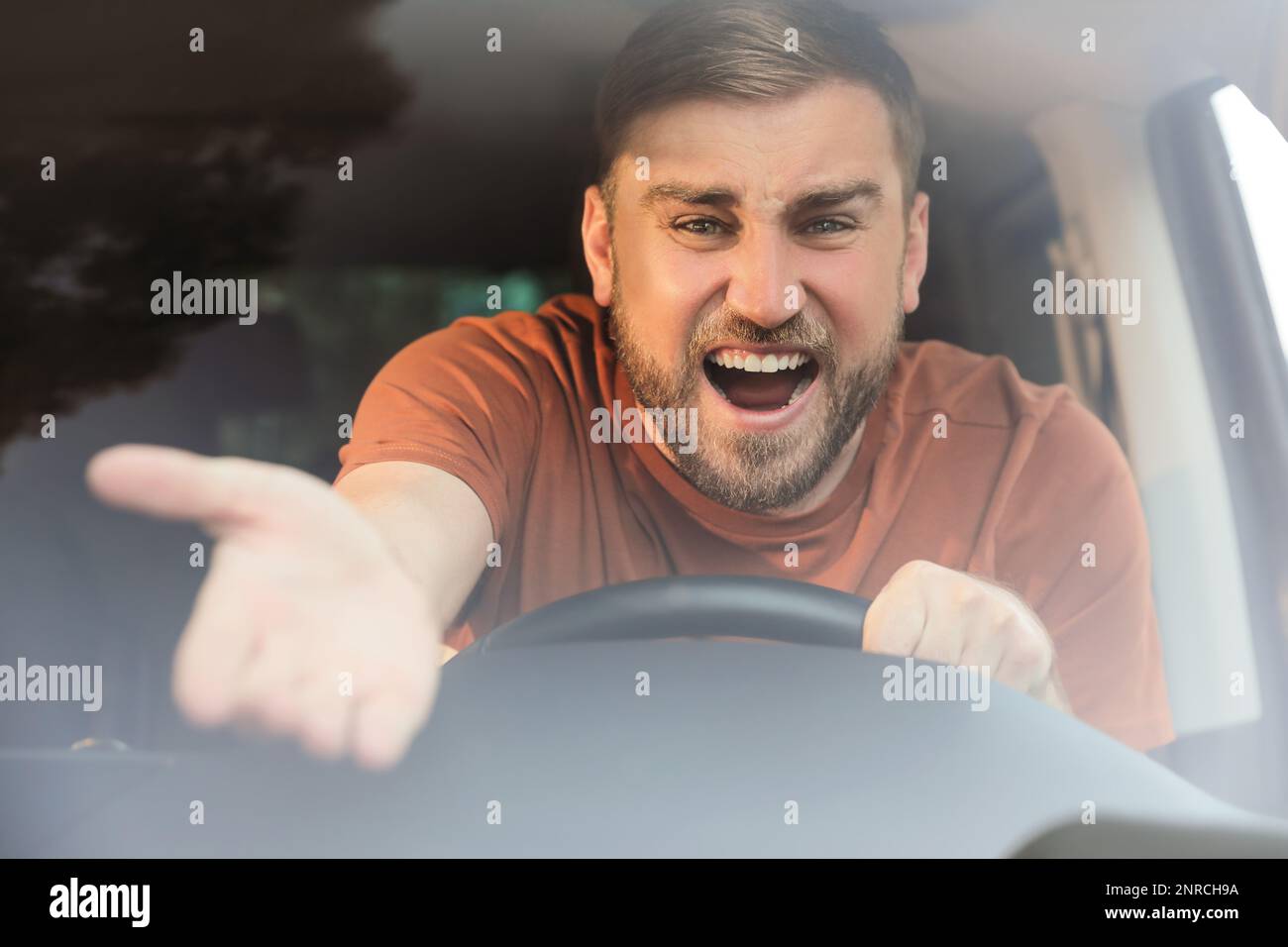 Emotional man in car, view through windshield. Aggressive driving ...
