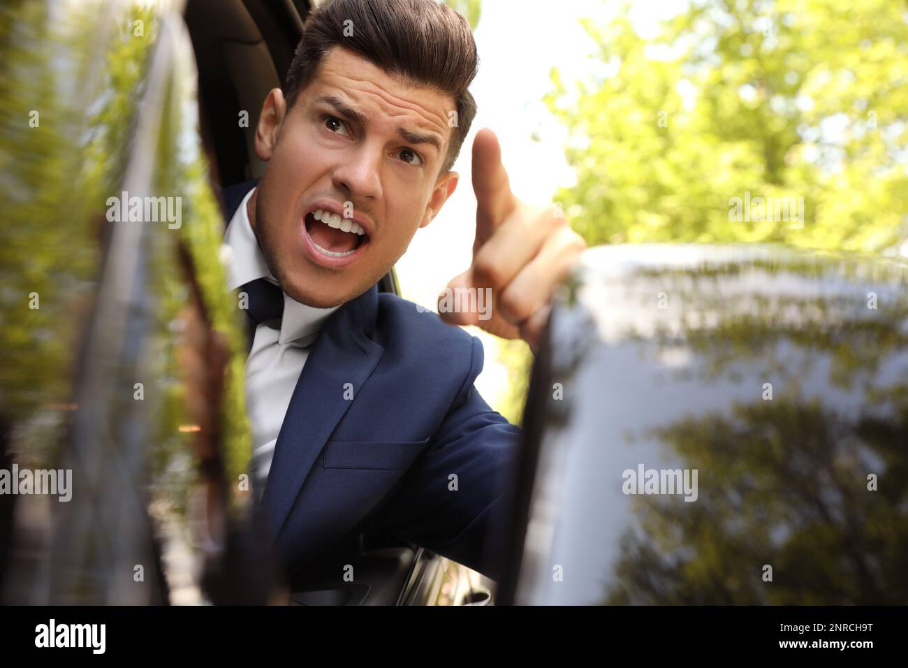 Emotional man yelling in car, view from outside. Aggressive driving ...