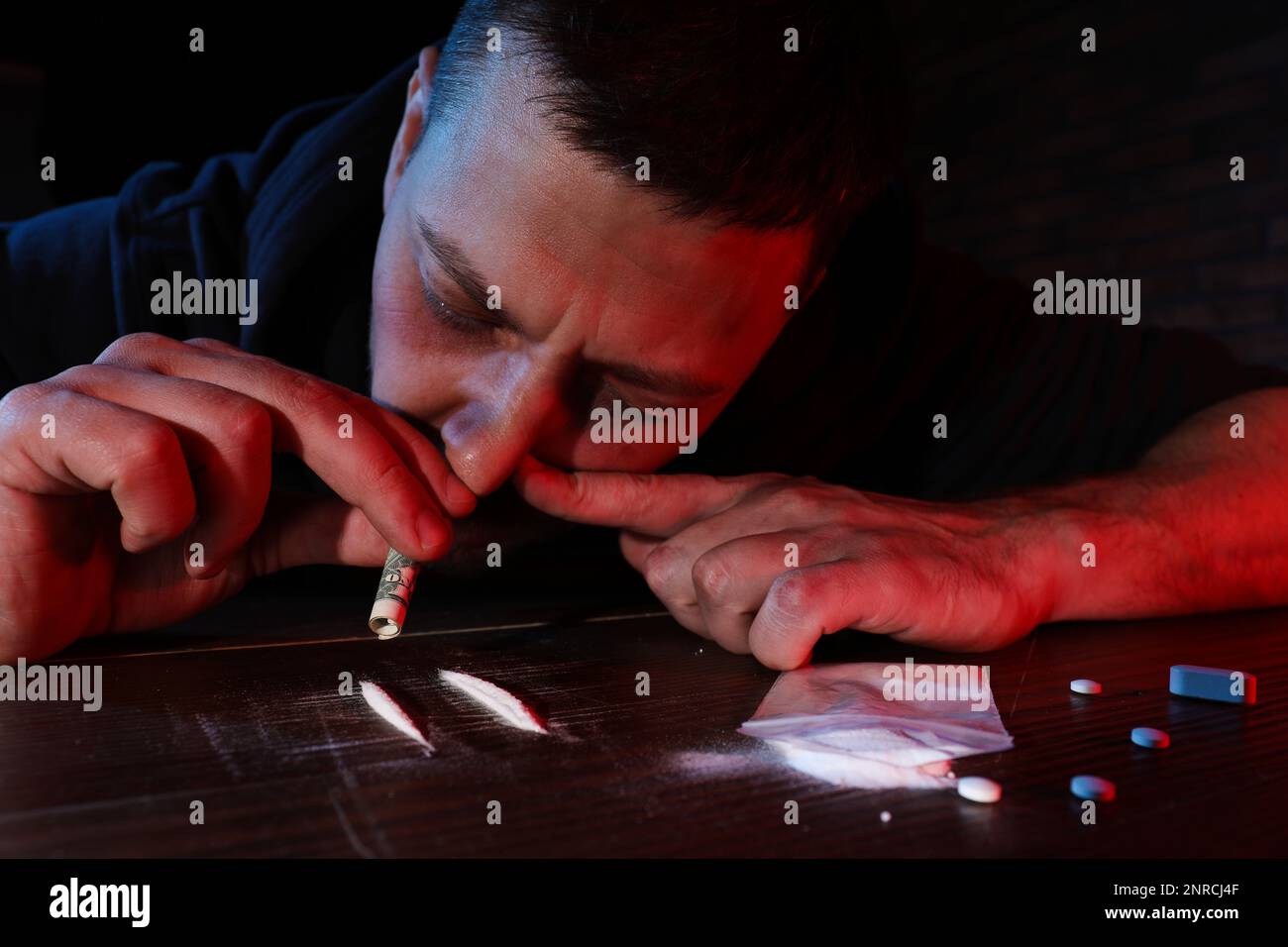 Drug addicted man taking cocaine at table Stock Photo - Alamy