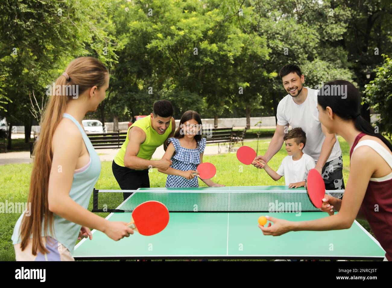 Happy families playing ping pong in park Stock Photo - Alamy