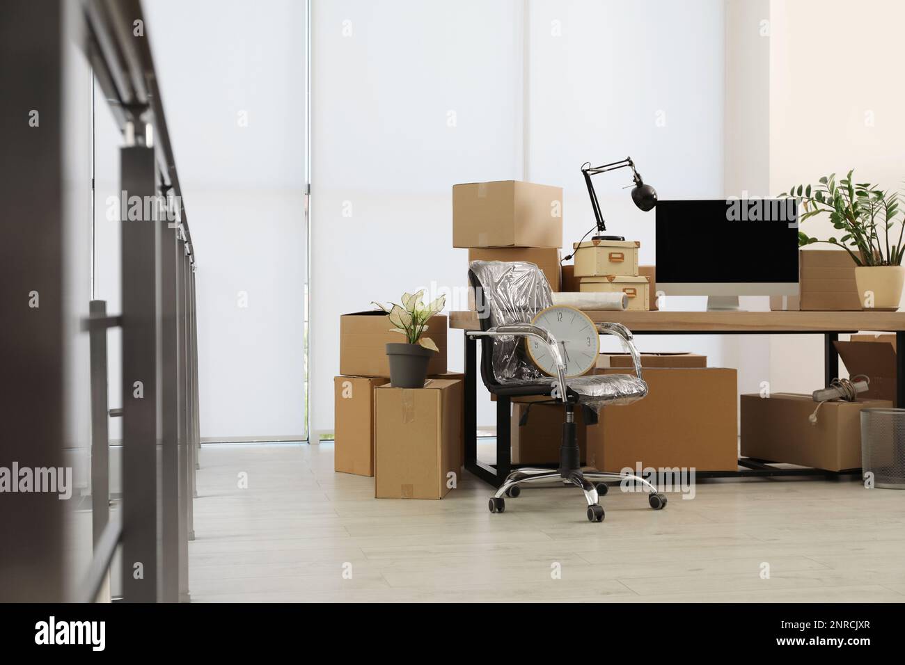 Cardboard boxes, computer and furniture in new office. Moving day Stock ...