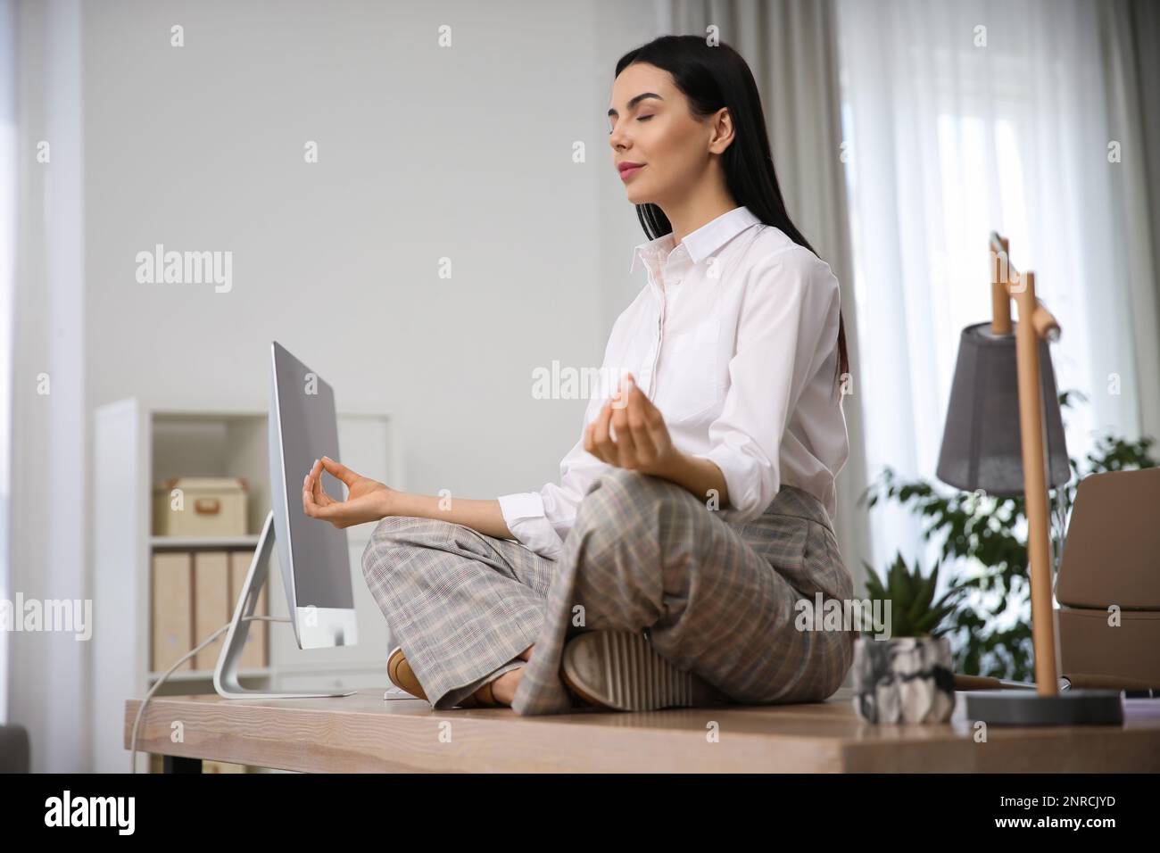 Young woman meditating at workplace. Stress relief exercise Stock Photo - Alamy