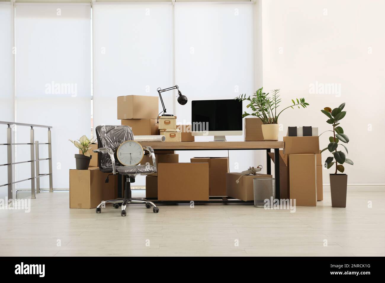 Cardboard boxes, computer and furniture in new office. Moving day Stock ...