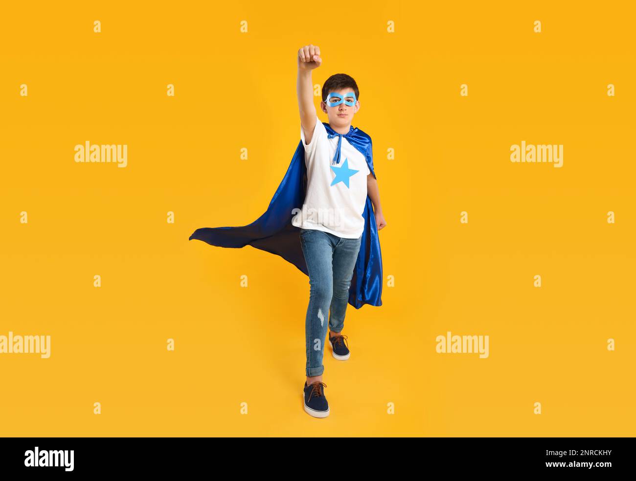 Teenage boy in superhero costume on yellow background Stock Photo - Alamy