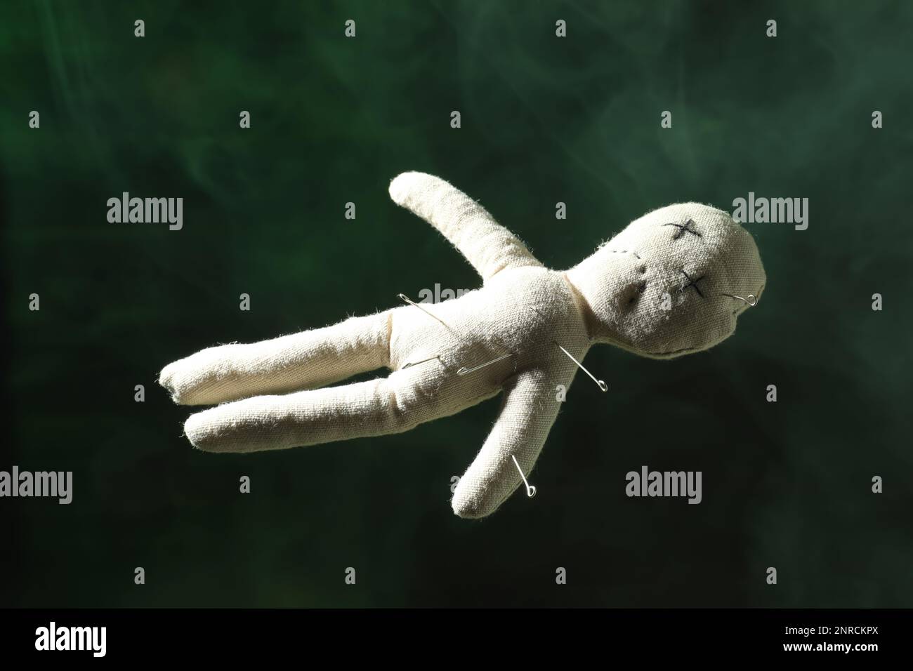 Voodoo doll with pins and smoke on dark green background Stock Photo ...