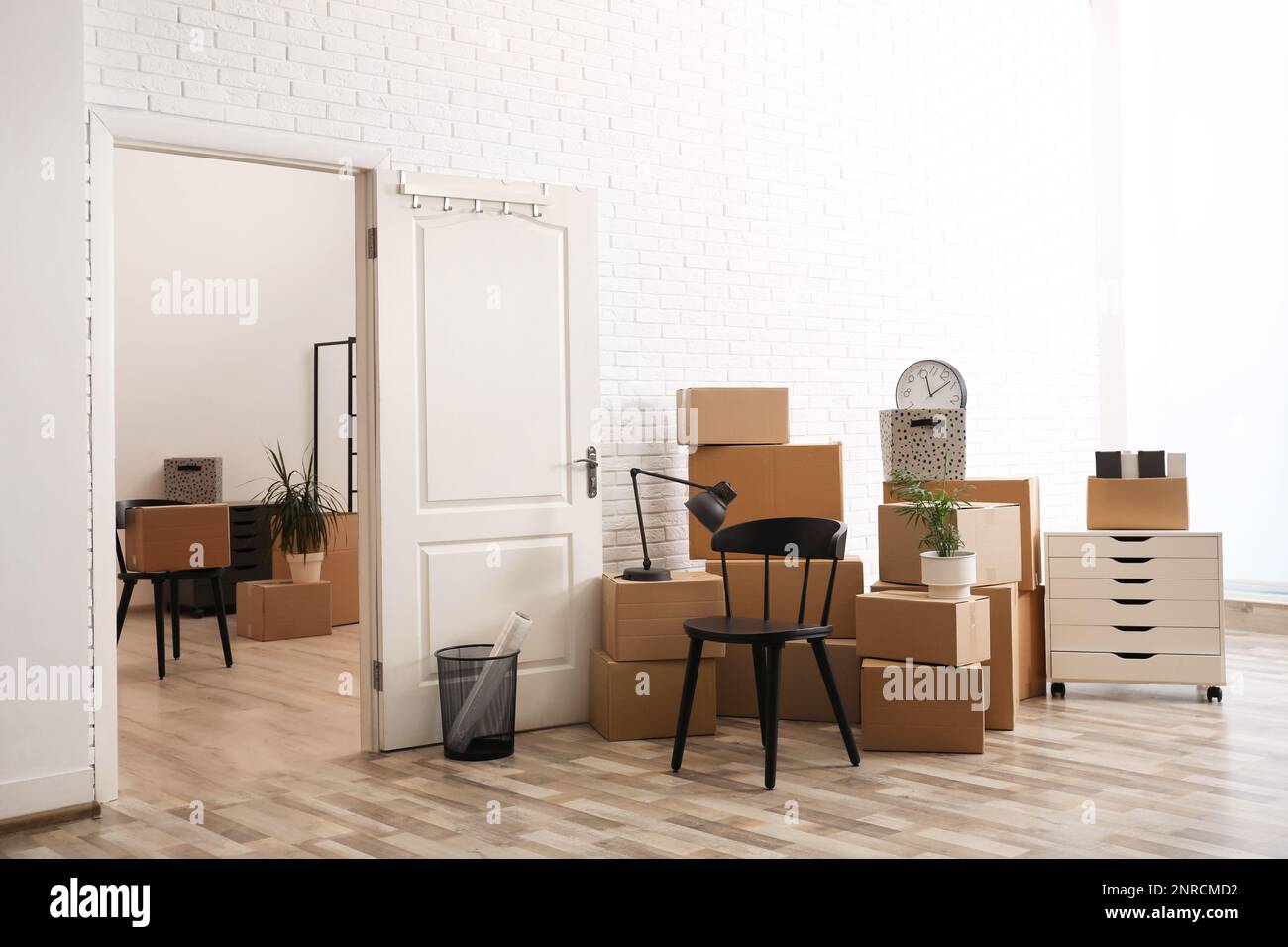 Cardboard boxes and furniture in new office. Moving day Stock Photo - Alamy