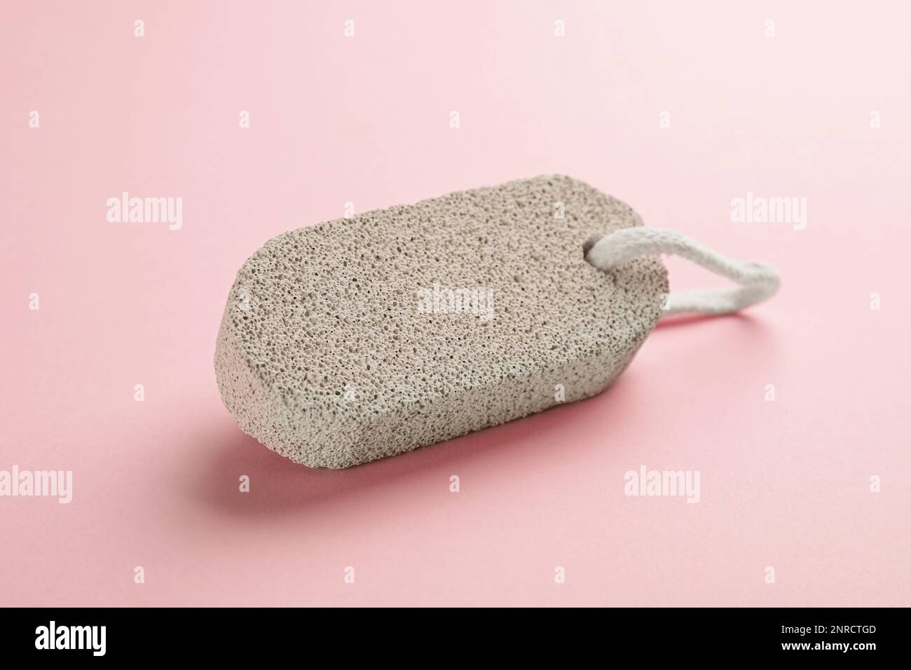 Pumice stone on pink background. Pedicure tool Stock Photo - Alamy