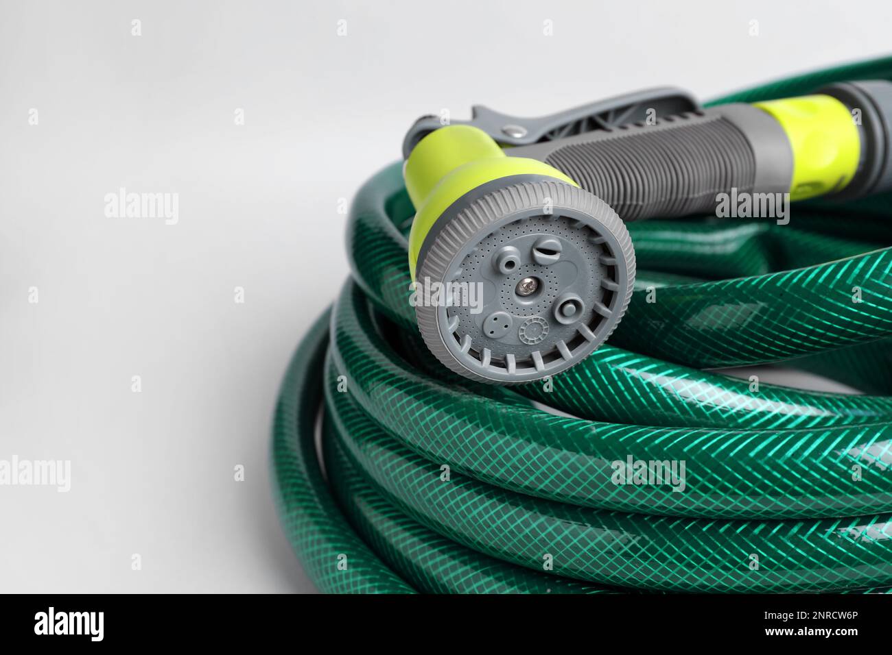 Watering hose with sprinkler on light grey background, closeup. Space ...