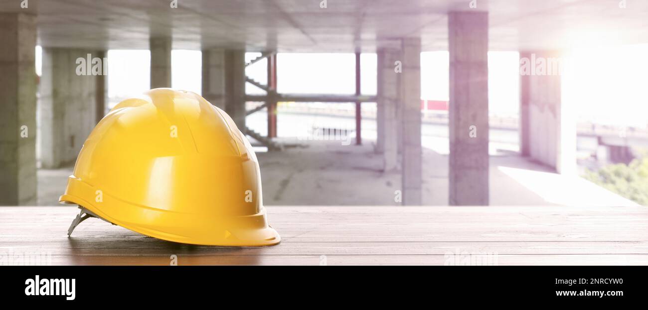 Hard hat on white wooden surface at construction site with unfinished ...