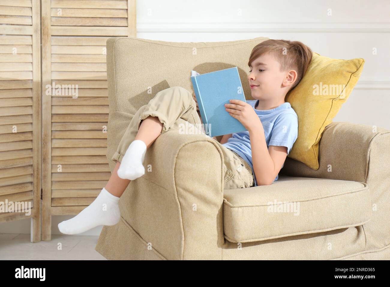 Little boy reading in armchair hi-res stock photography and images - Alamy