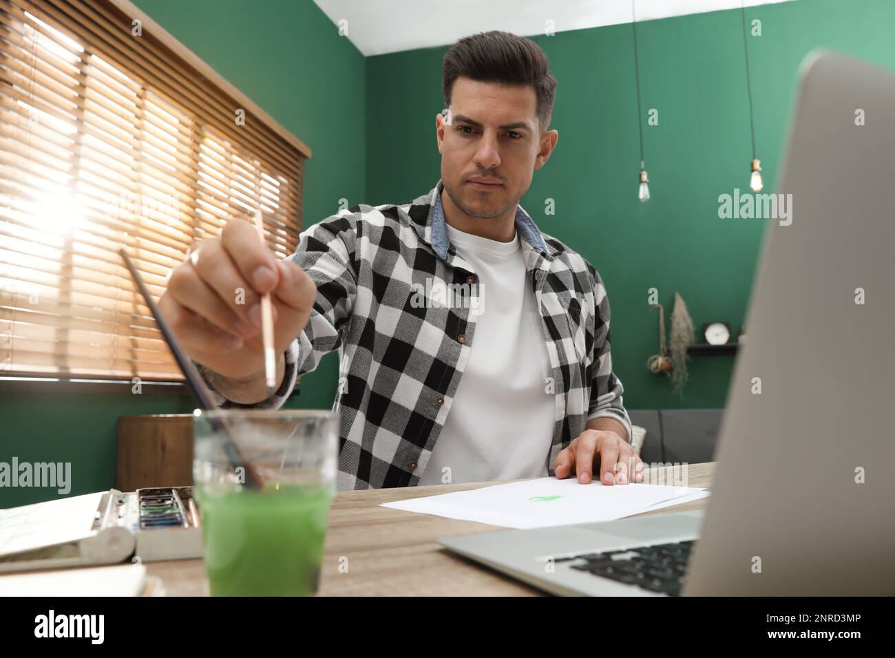 Man drawing with paints at online lesson indoors. Distance learning ...