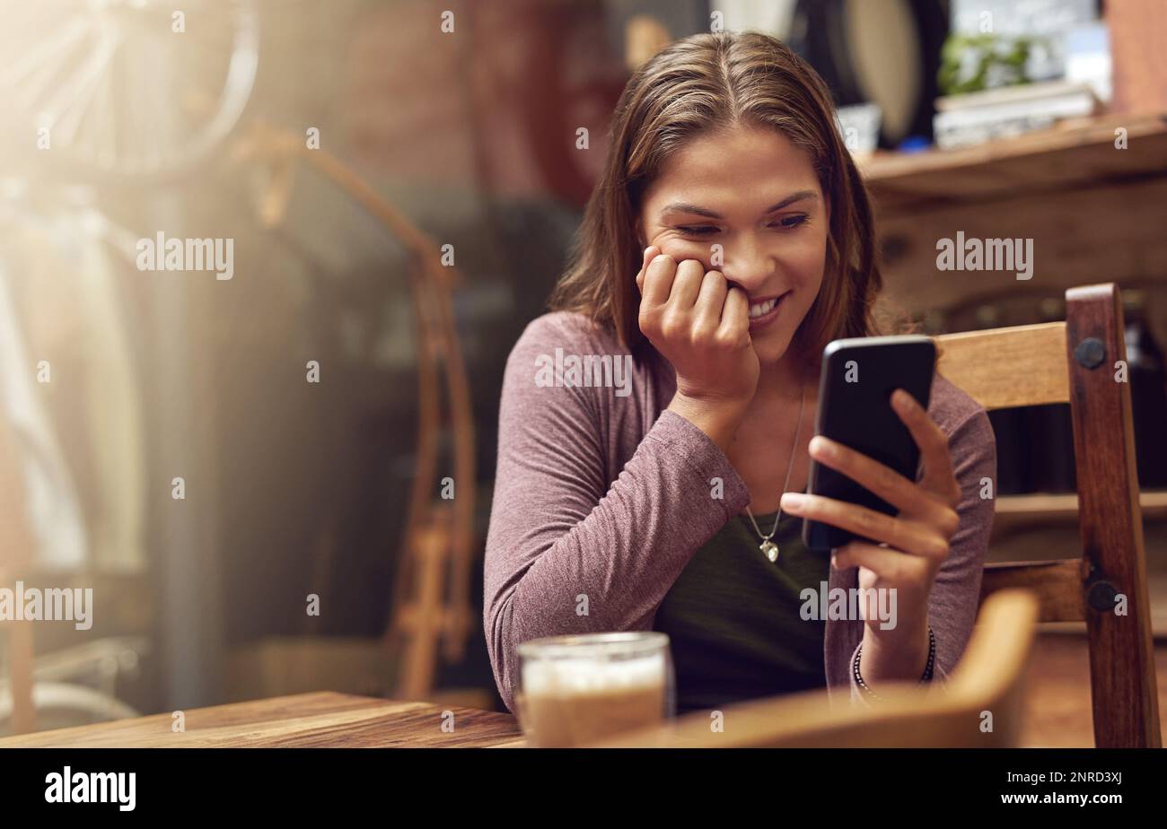 That feeling when he texts you back. a young woman using her phone in a ...