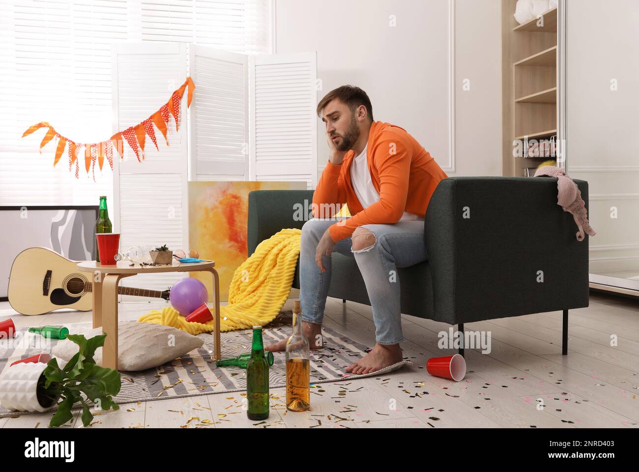 Tired drunk man on sofa in messy room after party Stock Photo - Alamy