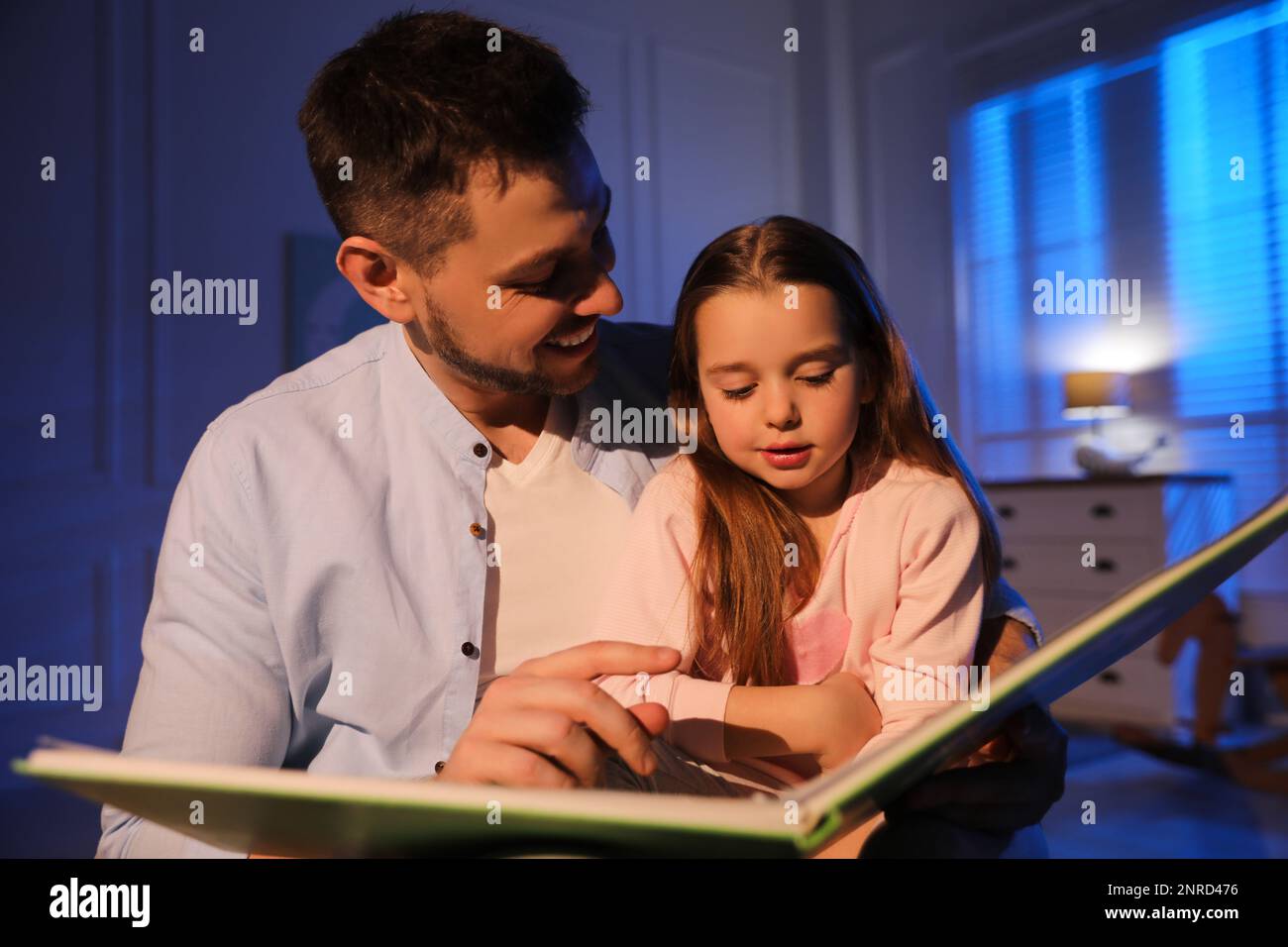 Father reading bedtime story to his daughter at home Stock Photo - Alamy