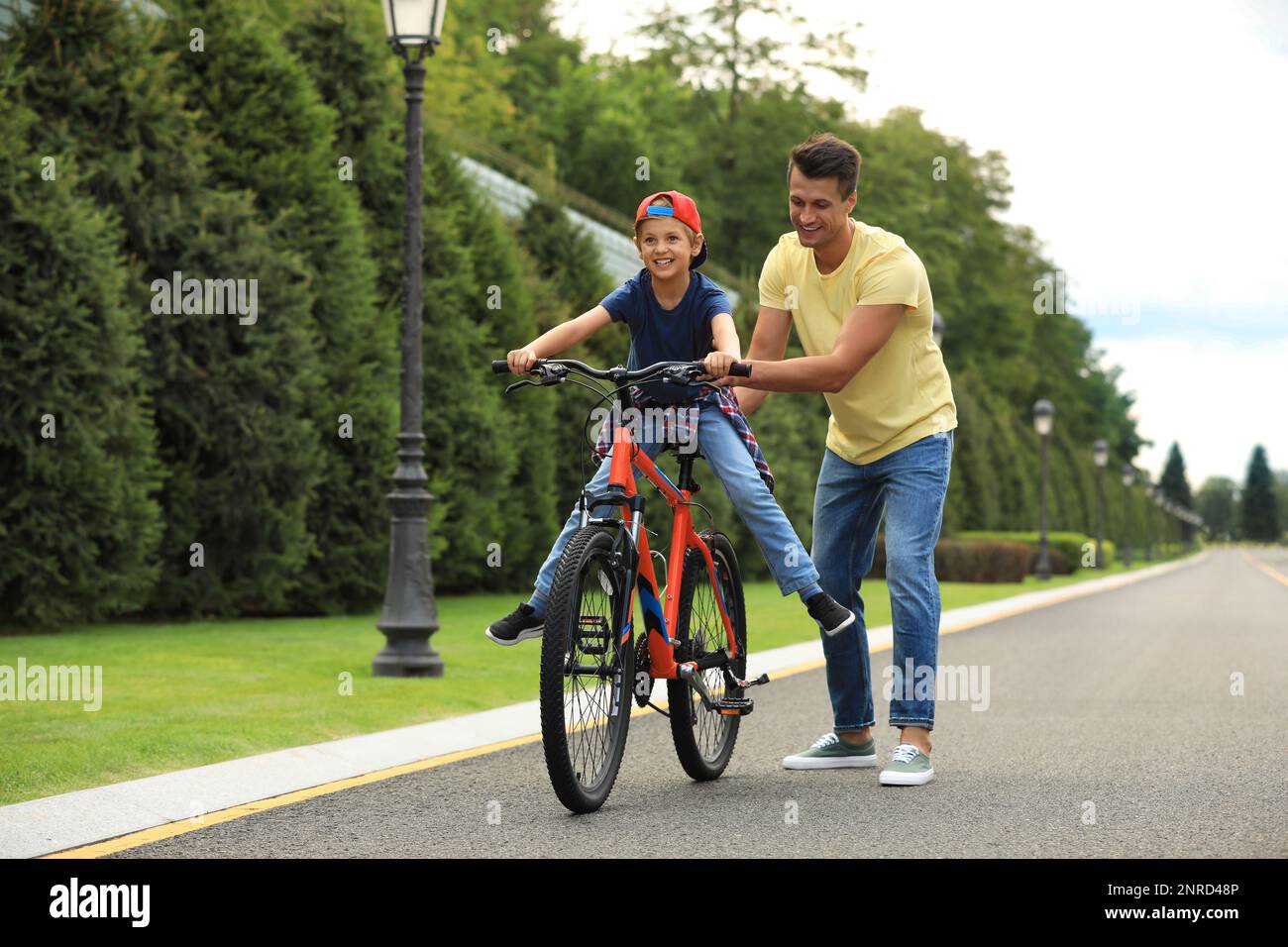 Father teaching son to ride bicycle hi-res stock photography and images ...