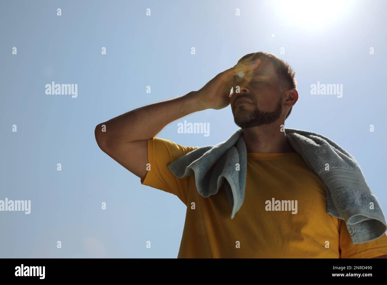 Man with towel suffering from heat stroke outdoors Stock Photo - Alamy