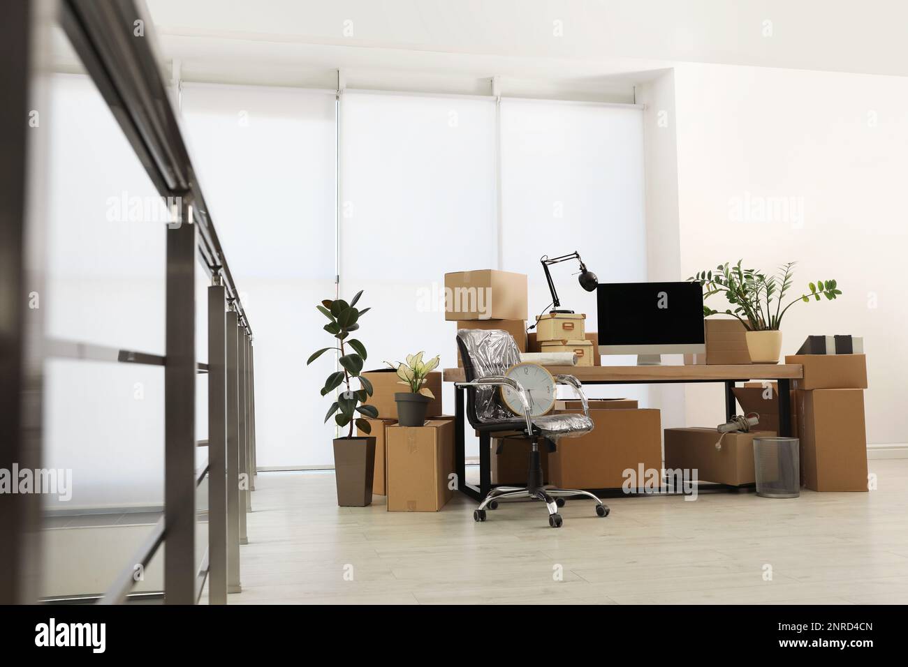 Cardboard boxes, computer and furniture in new office. Moving day Stock ...