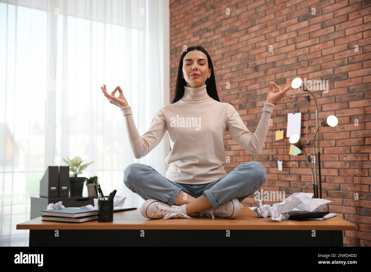 Young woman meditating at workplace. Stress relief exercise Stock Photo ...