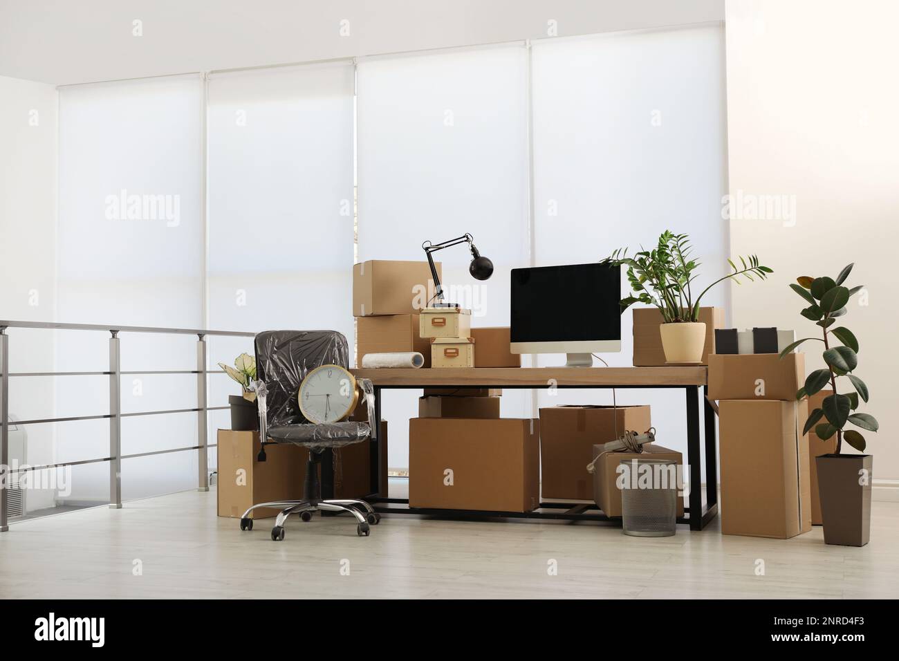 Cardboard boxes, computer and furniture in new office. Moving day Stock ...