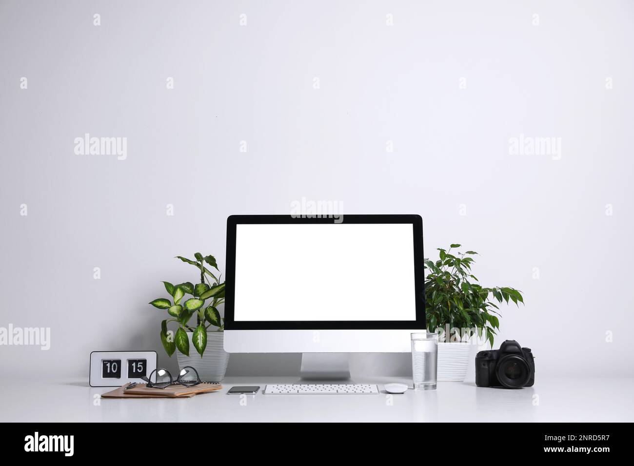 Comfortable workplace with modern computer on table near white wall ...
