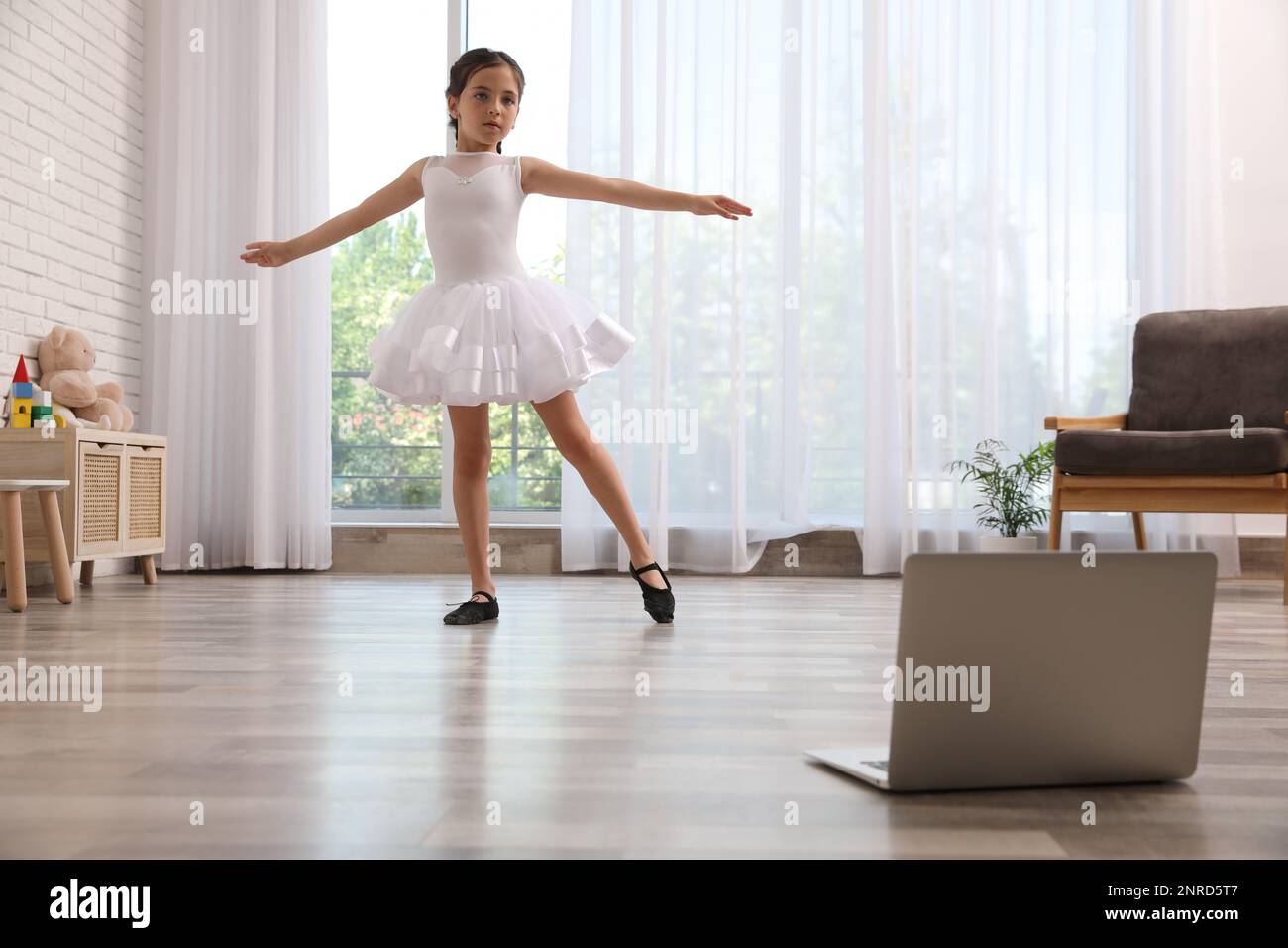 Cute little girl taking online dance class at home Stock Photo - Alamy