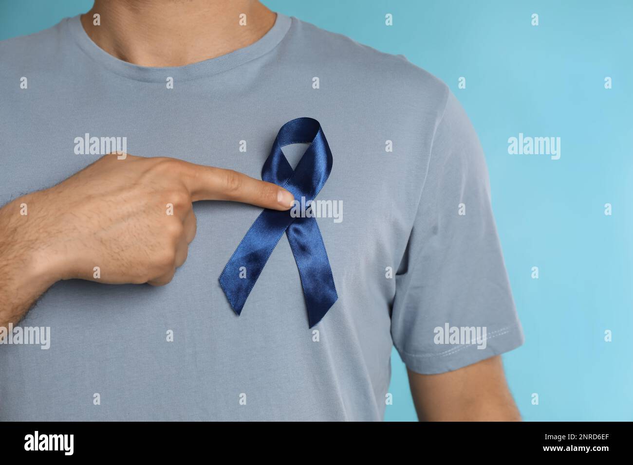 Man with ribbon on light blue background, closeup. Urology cancer ...