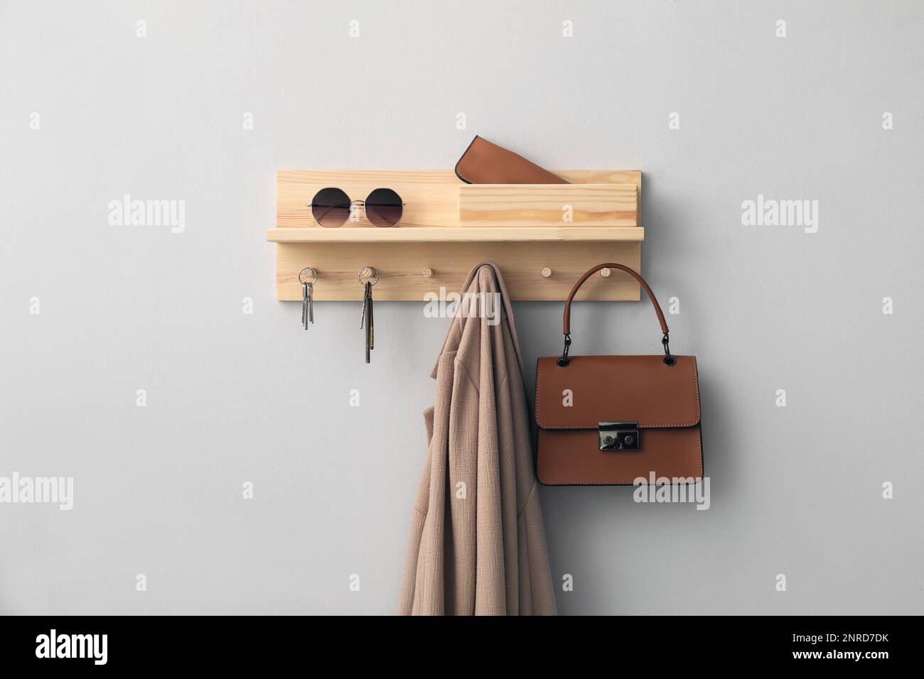 Wooden hanger for keys with different stuff on light grey wall Stock ...