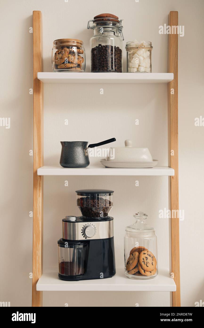 Modern coffee grinder on shelving unit in kitchen Stock Photo - Alamy