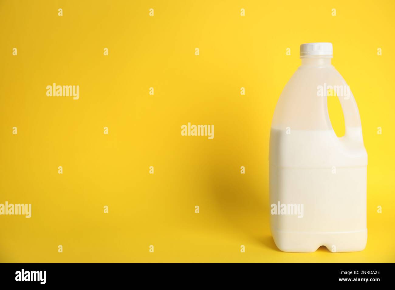 Gallon bottle of milk on yellow background. Space for text Stock Photo ...