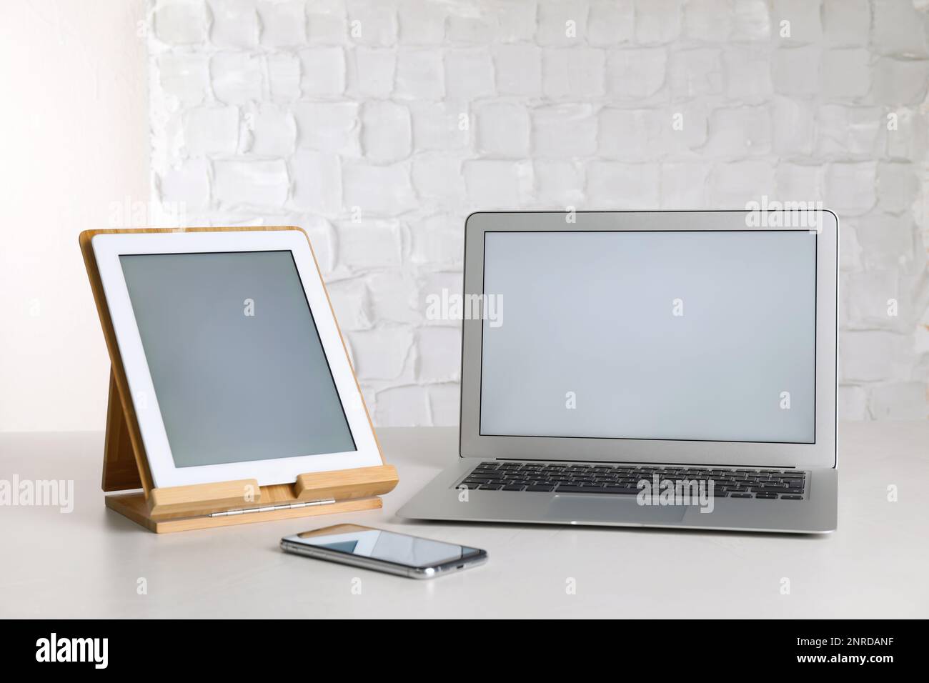 Modern laptop, tablet and smartphone on table indoors. Space for design ...