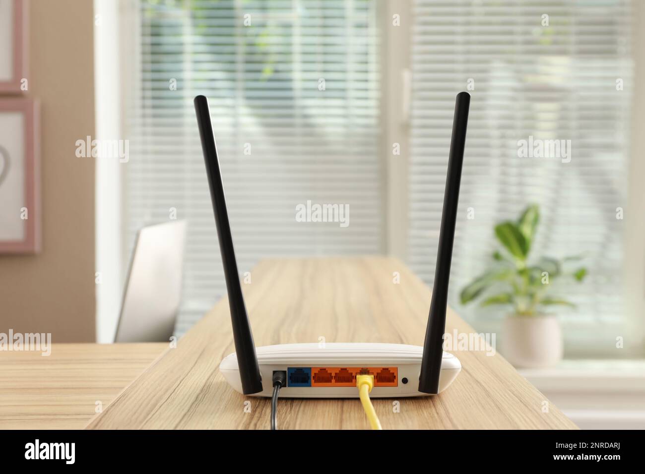 Modern wi-fi router on wooden counter indoors Stock Photo - Alamy
