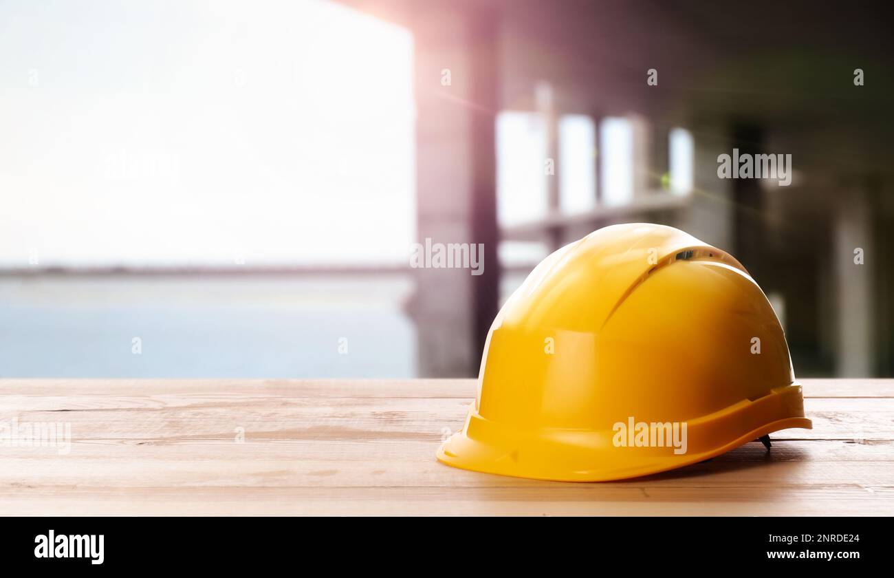 Hard hat on wooden surface at construction site with unfinished ...