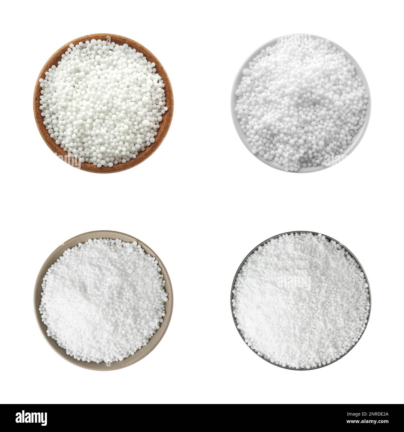 Set with ammonium nitrate pellets in bowls on white background, top ...