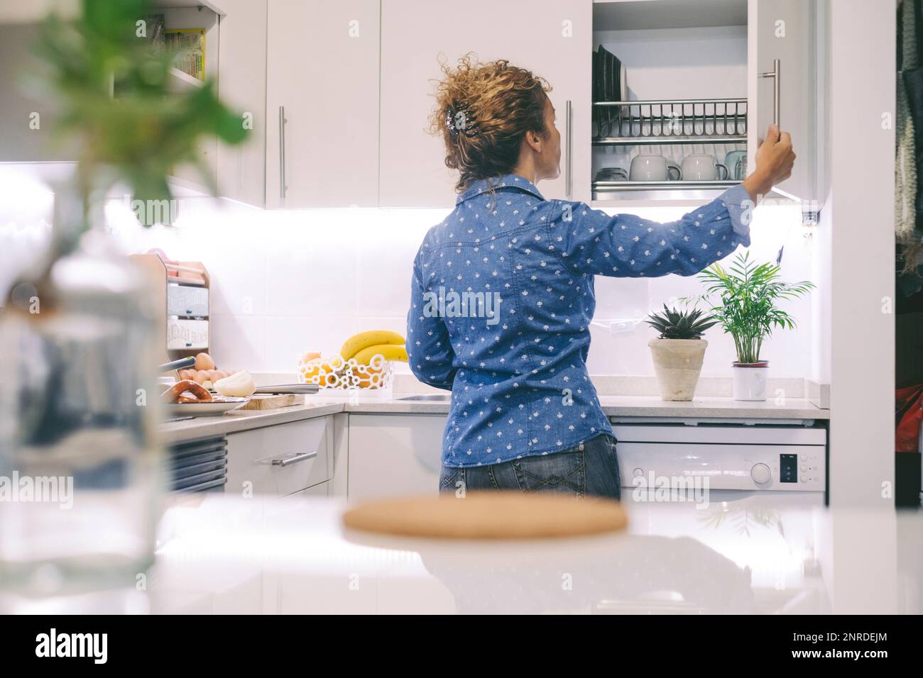 Real home life concept lifestyle. Woman back view using kitchen home ...