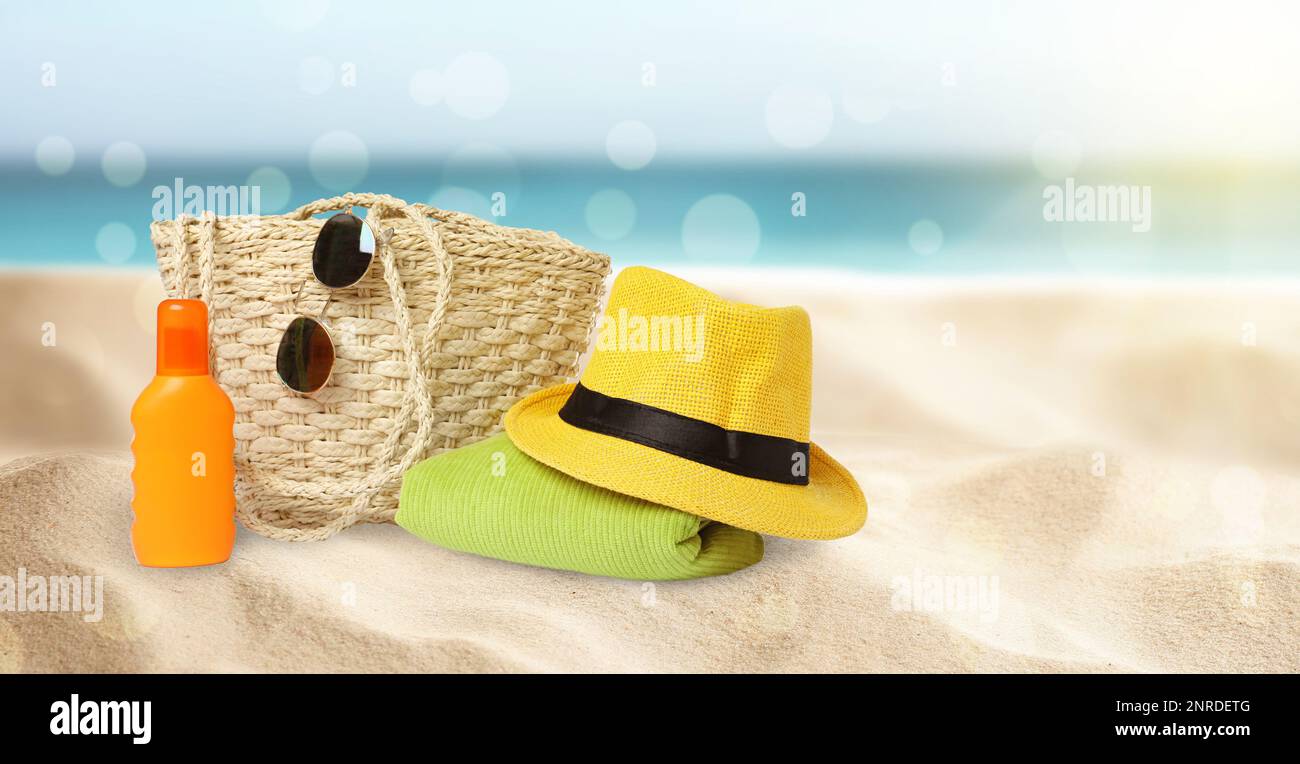 Stylish bag with different accessories on tropical sandy beach, banner ...