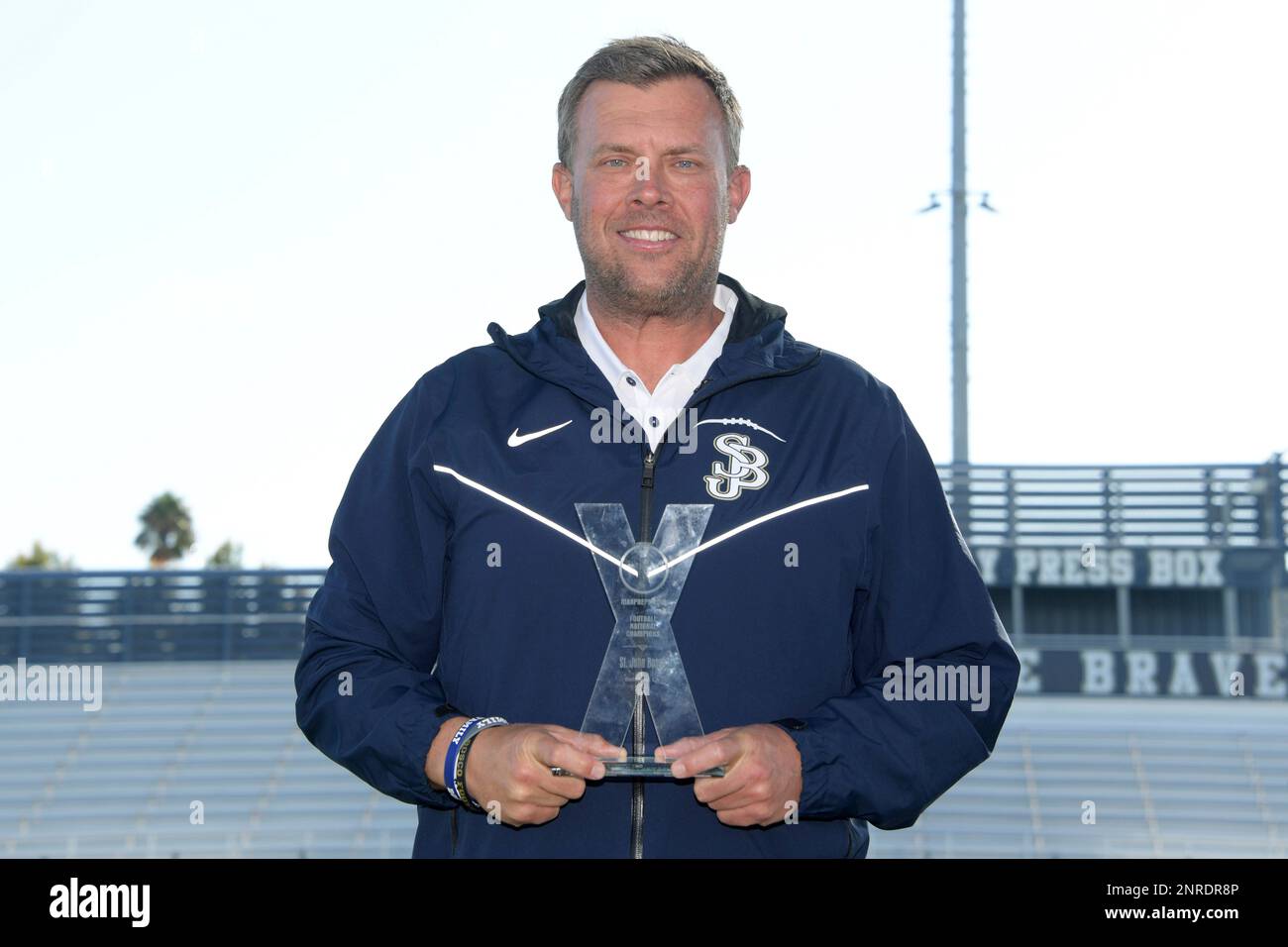 St. John Bosco Braves coach Jason Negro poses with trophy during a ...