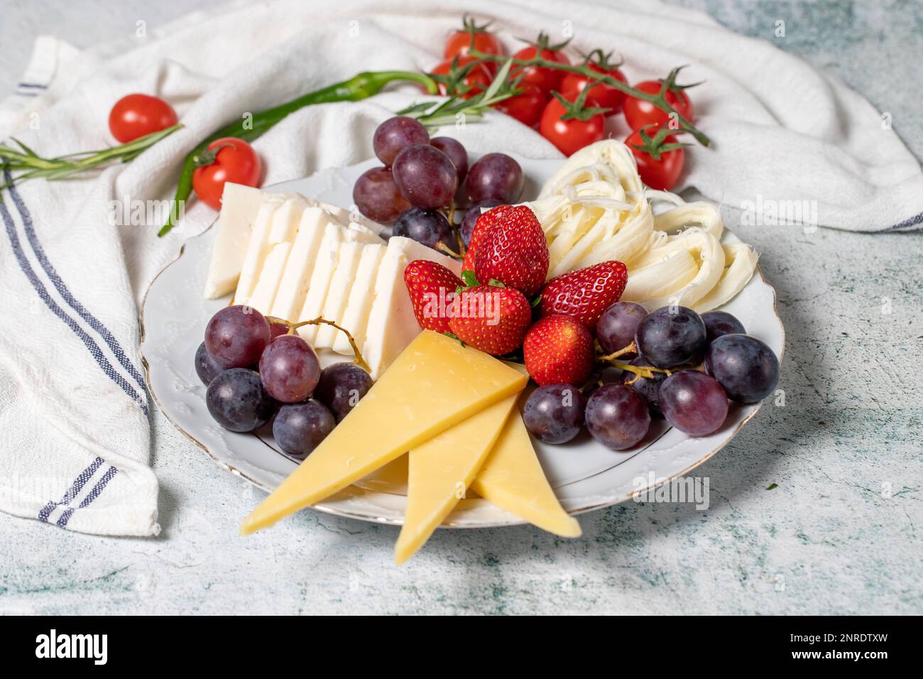 Cold cheese plate, cheese set platter. Strawberry, grape and cheese assortment on gray ...