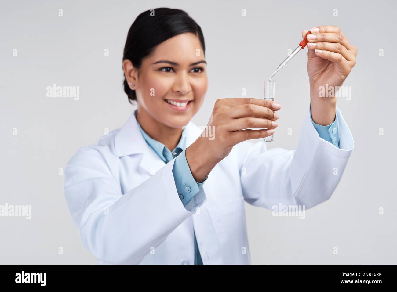 Mixing the solutions one drop at a time. an attractive young female ...