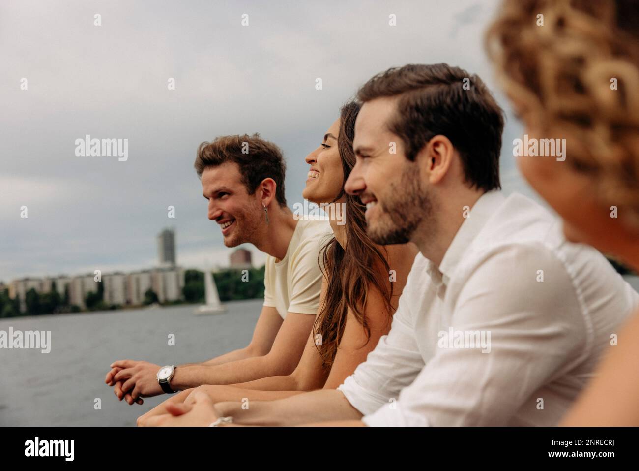 Side view of happy male and female friends talking to each other Stock ...