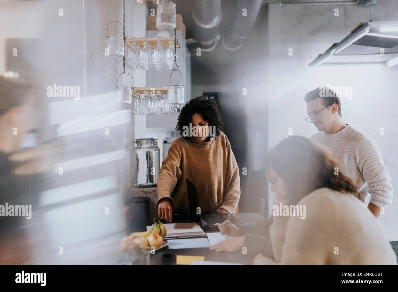 Multiracial male and female colleagues discussing in cafeteria at ...
